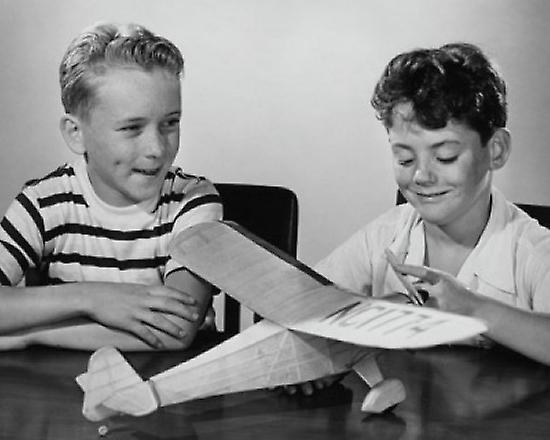 Boy making a model airplane and another boy sitting beside him Poster ...