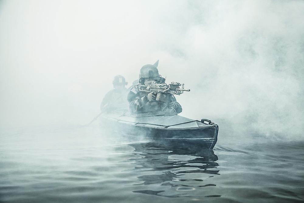 Special forces operator armed with machine gun, paddling Army kayak ...